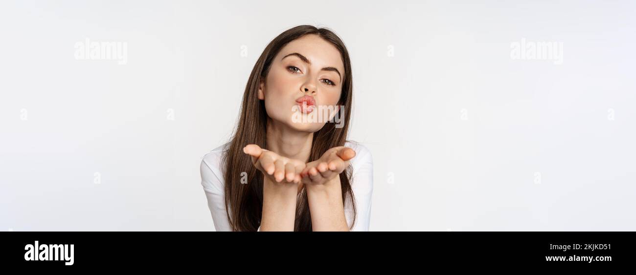 Feminine woman sending air kiss at camera, coquettish flirty pose ...