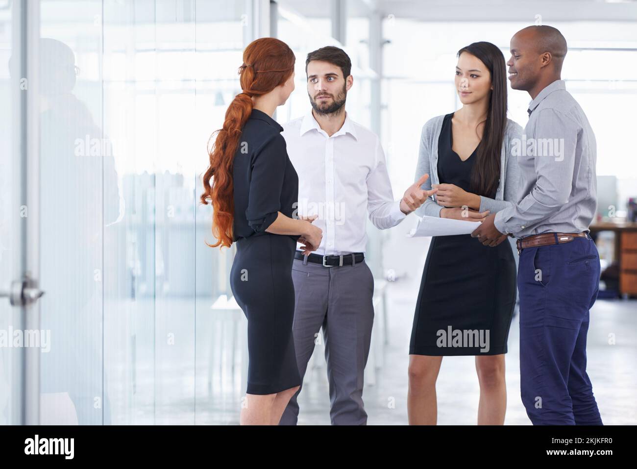 Theyre a dynamic corporate team. businesspeople discussing paperwork in ...