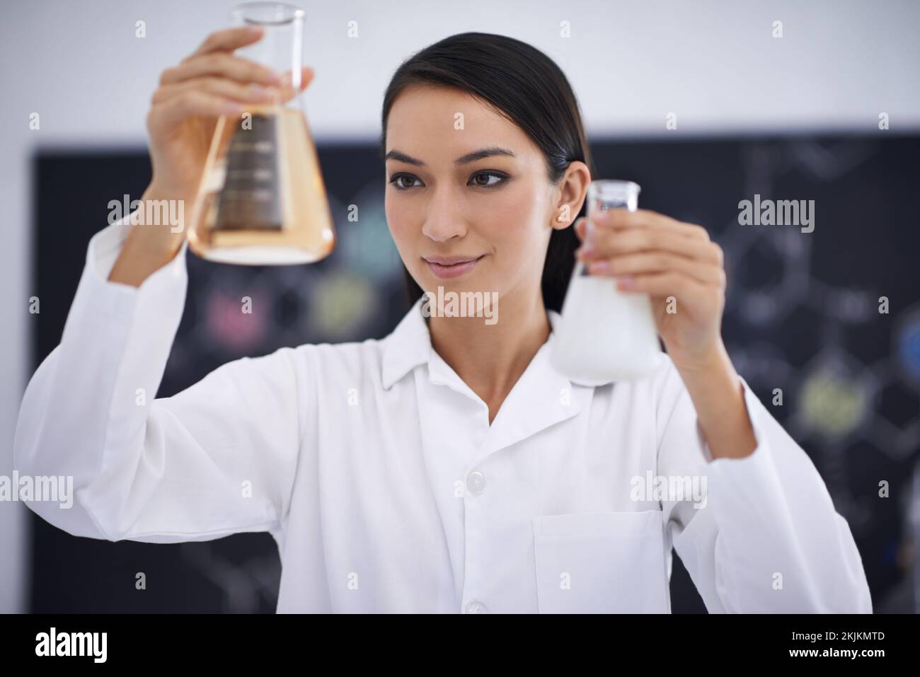 Which beaker is the right one. a female scientist observing liquids in ...