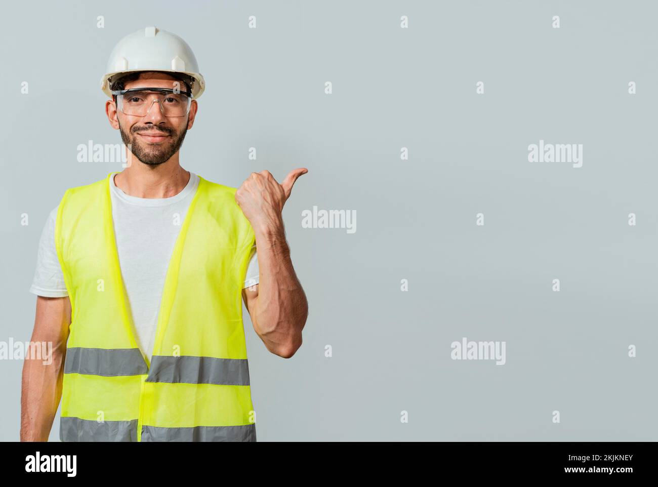 Portrait of engineer man pointing aside. Construction worker with vest ...