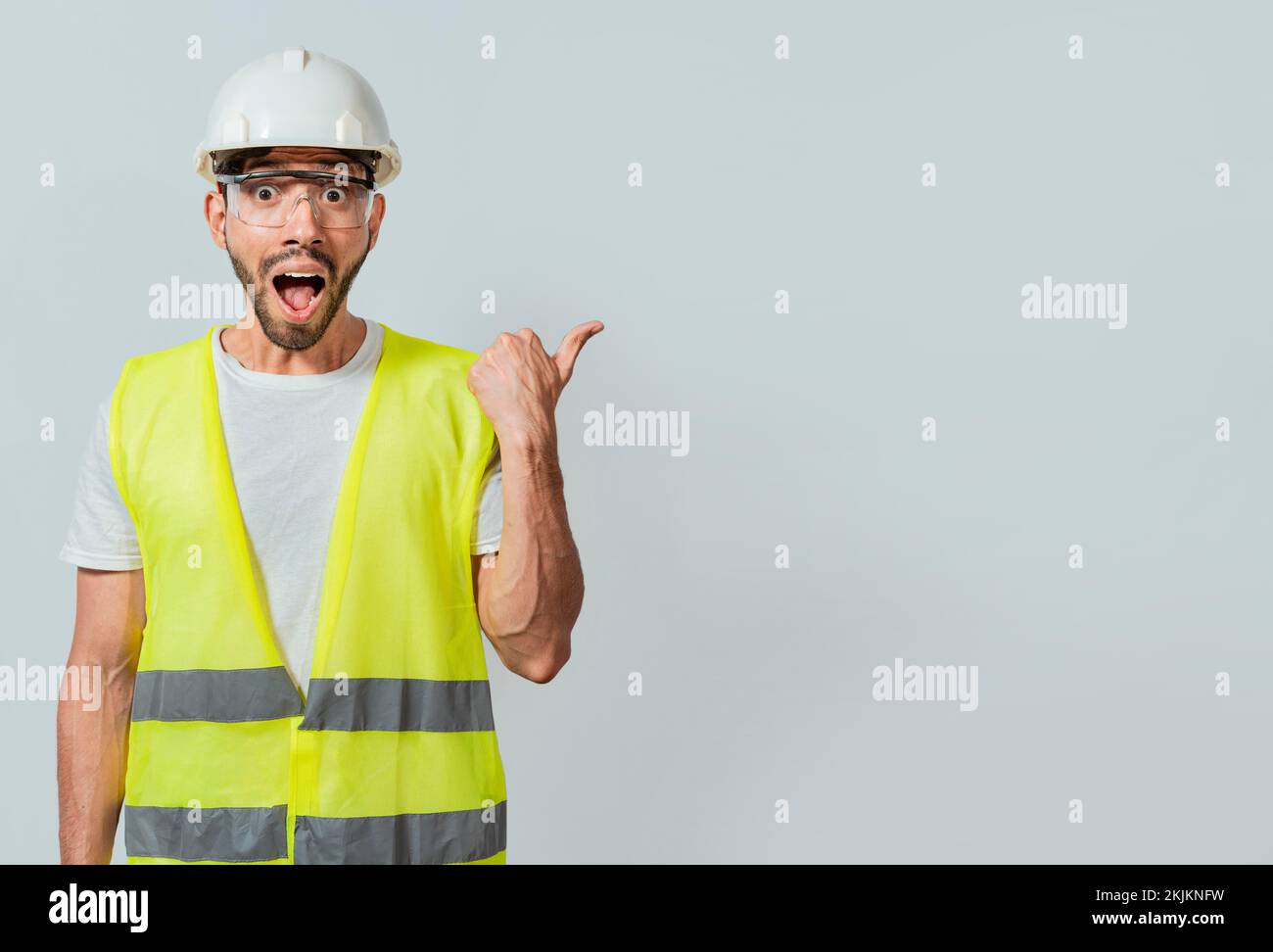 Surprised face construction worker pointing at an advertisement ...