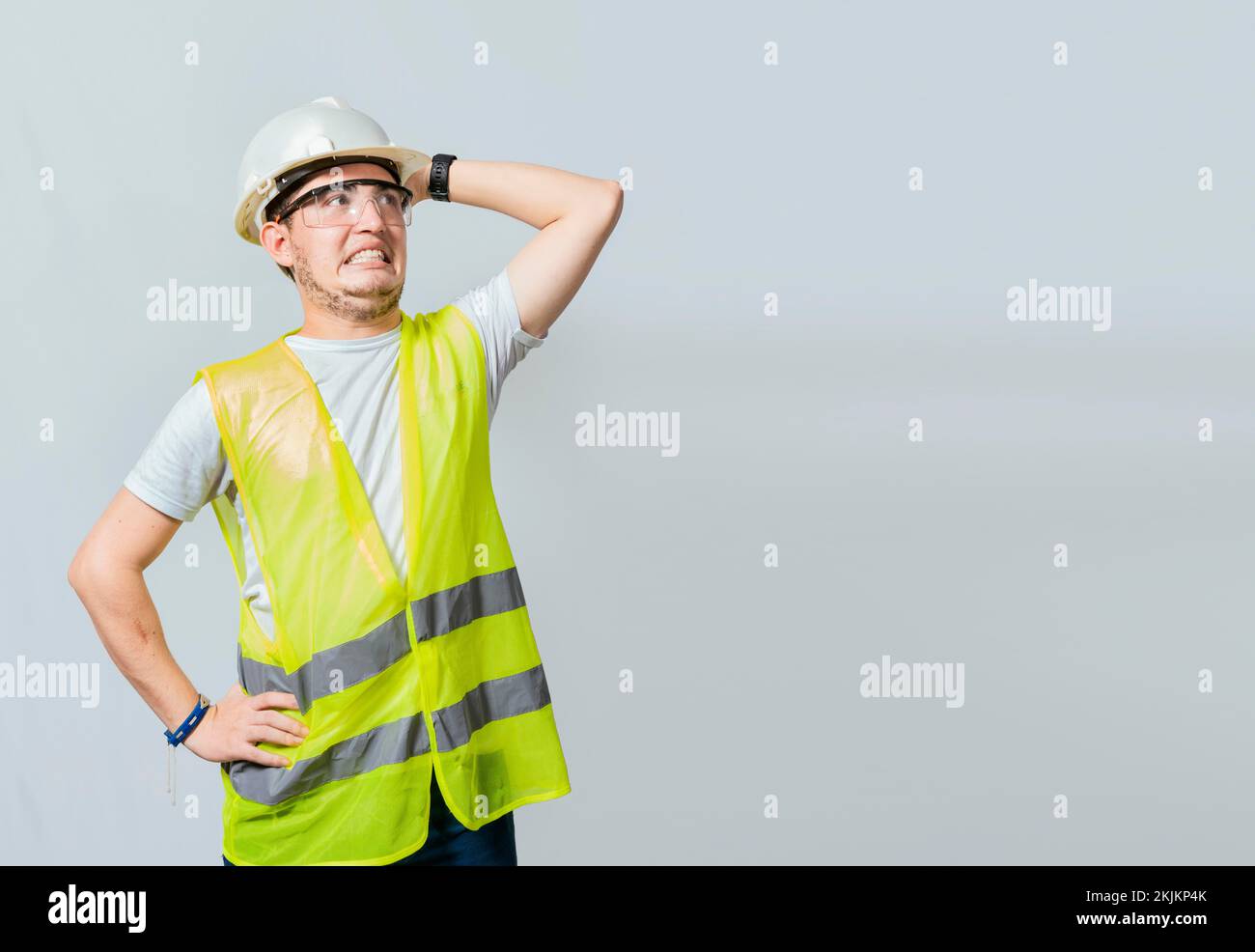 Worried engineer man looking up. Troubled young engineer holding his ...