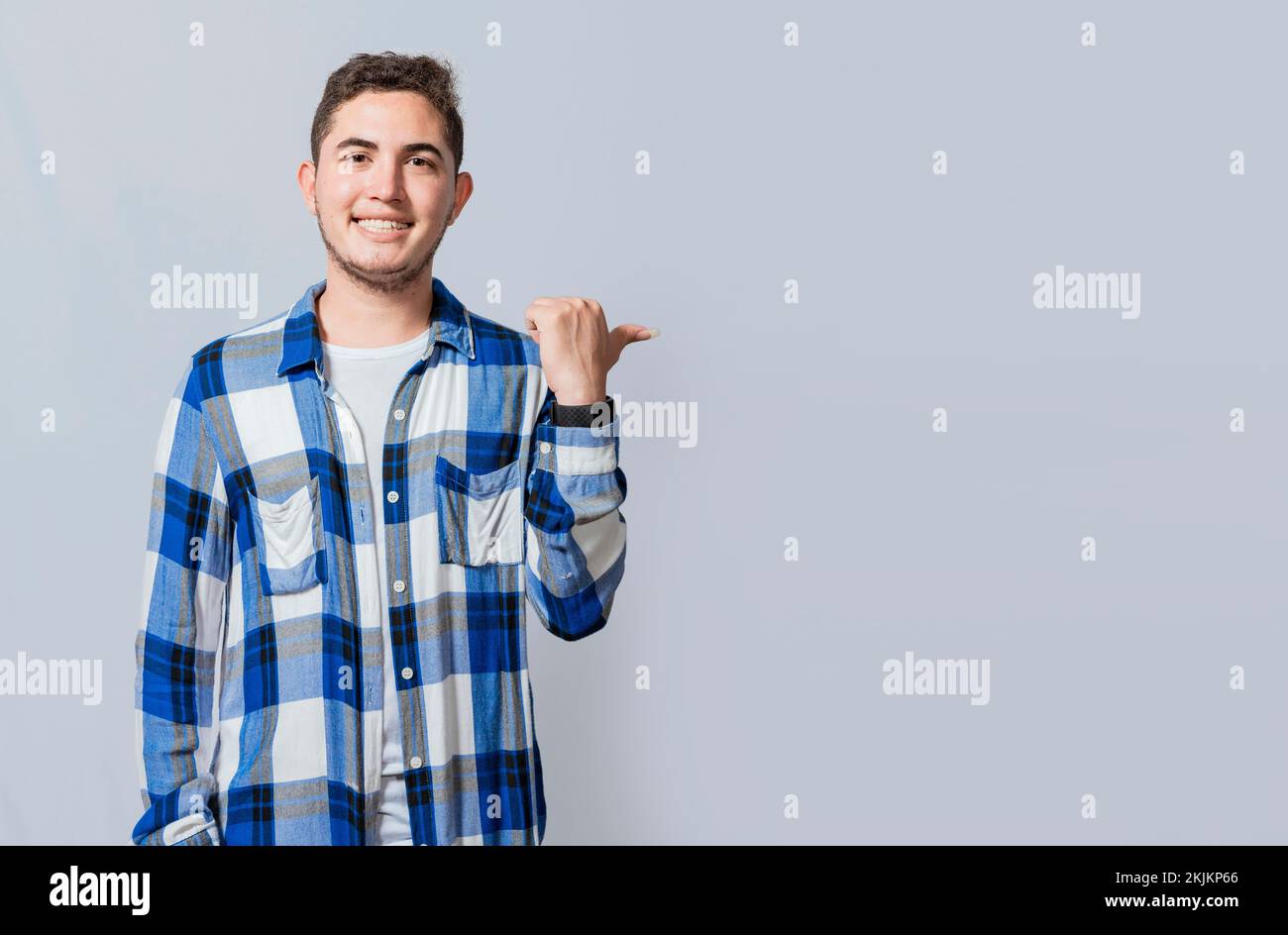 Cheerful guy with friendly smile pointing to the side isolated. Smiling ...