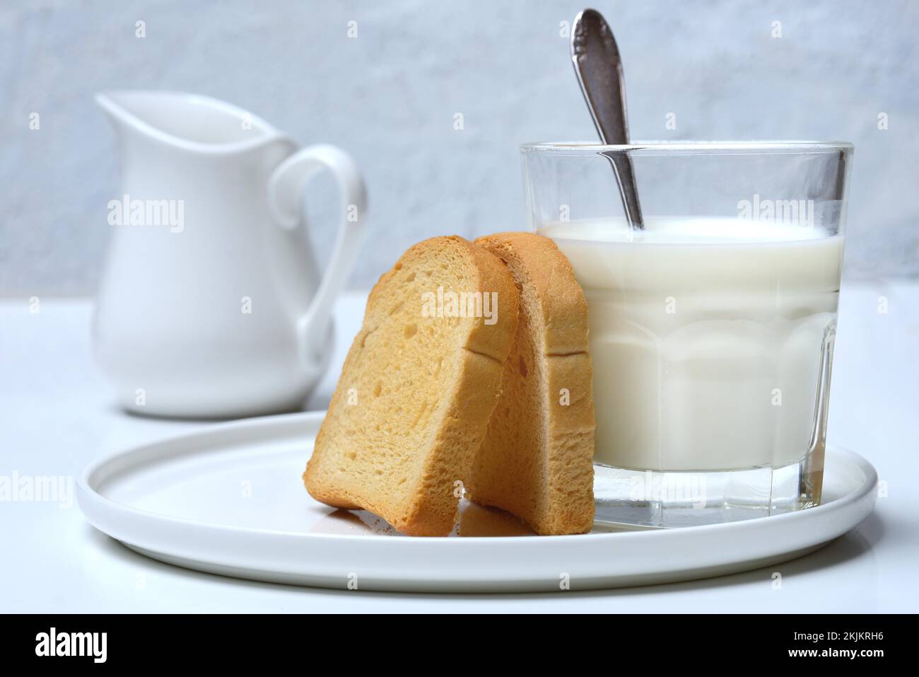 Rusk and glass of milk with spoon Stock Photo - Alamy