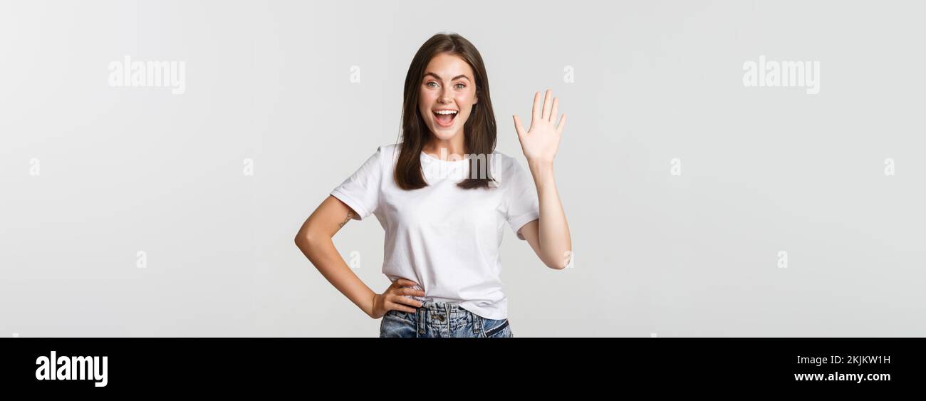 Friendly smiling girl waving hand to say hi, greeting someone Stock ...