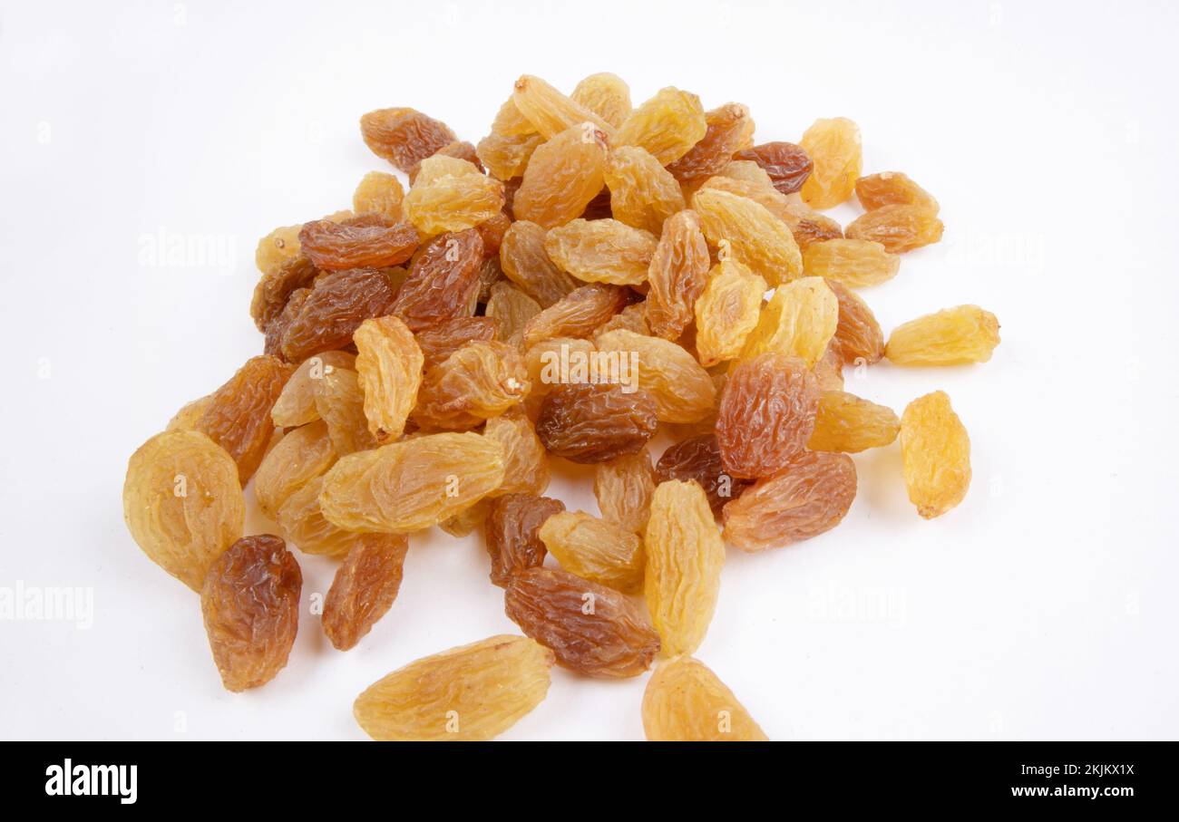 Close-up of golden raisins dry grapes isolated over white background ...