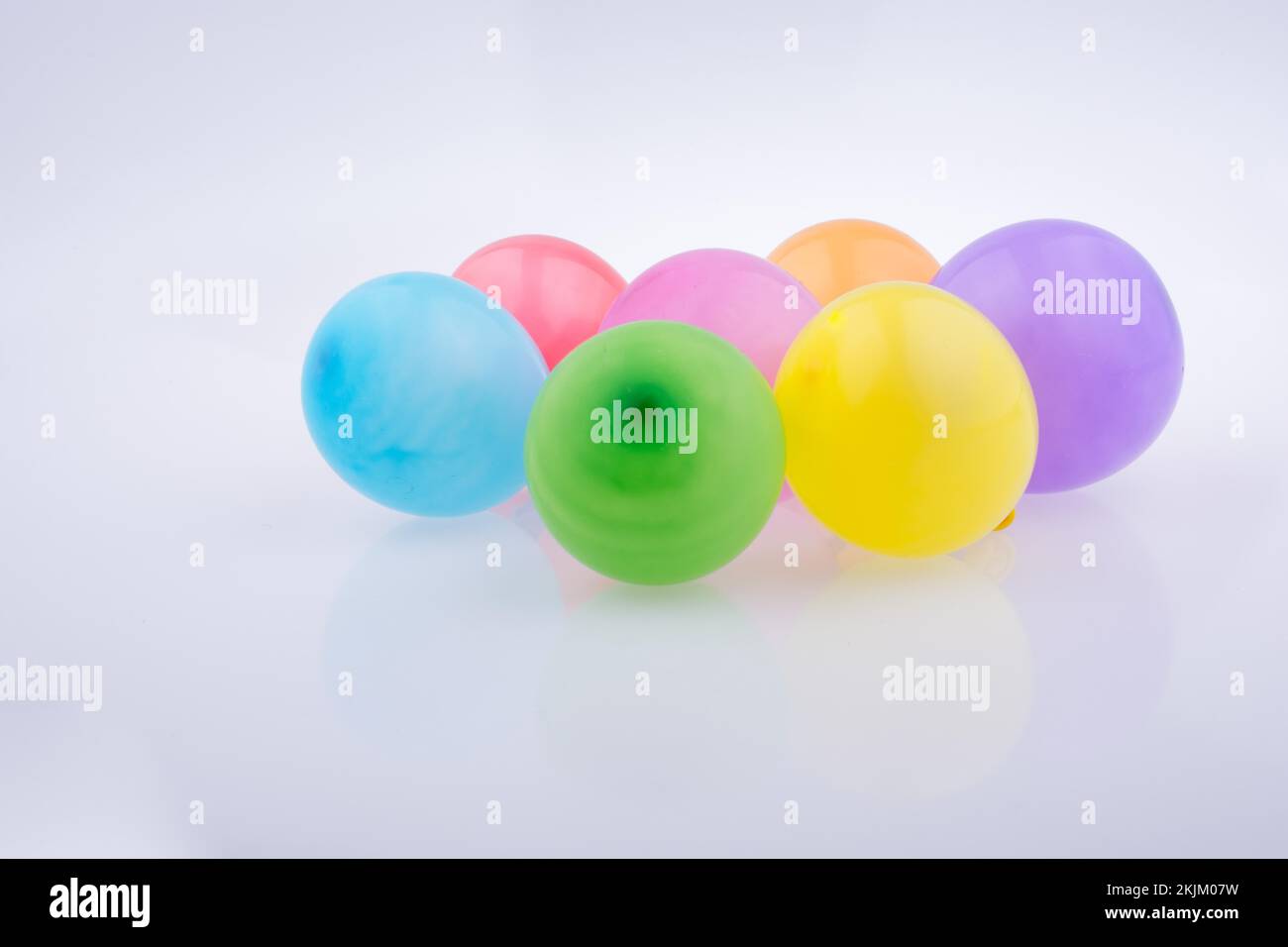 Colorful small balloons on a white background Stock Photo - Alamy