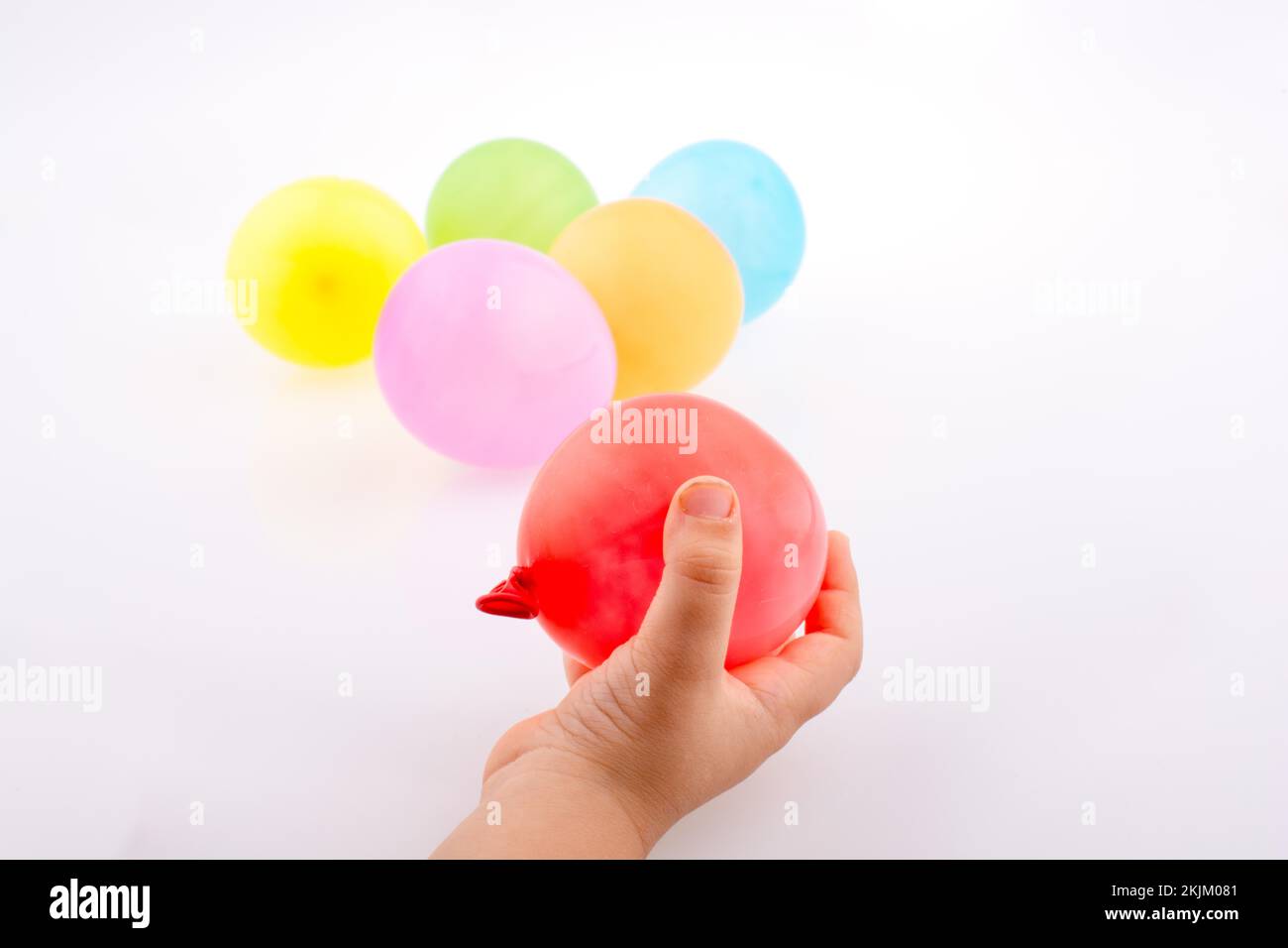 Hand holding a Colorful small balloon with colorful balloons on the ...