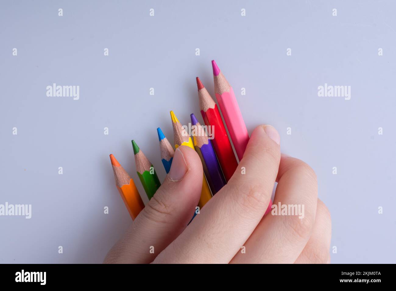 Hand holding color Pencils placed on a white background Stock Photo - Alamy