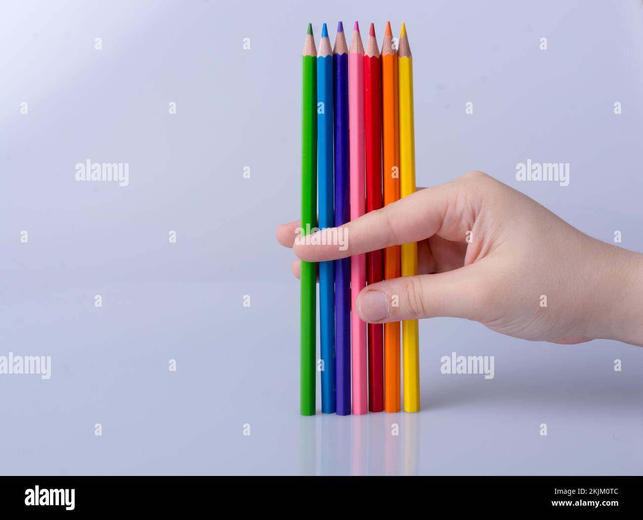 Hand holding color Pencils placed on a white background Stock Photo - Alamy