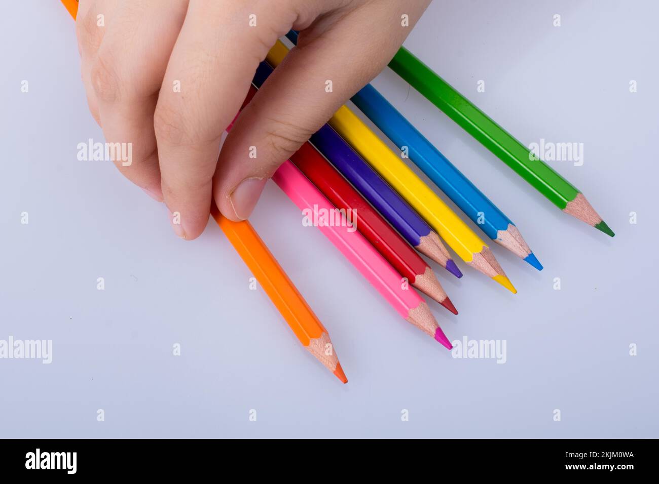 Hand holding color Pencils placed on a white background Stock Photo - Alamy