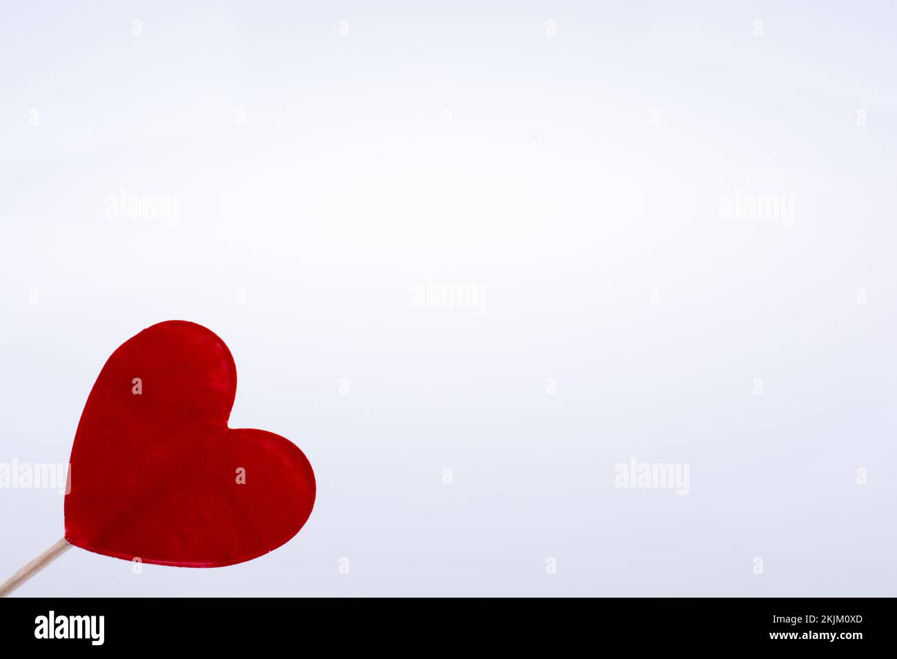 Little red color heart shape at the top of a stick Stock Photo - Alamy