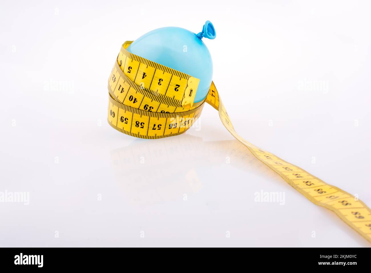 Yellow color measuring tape and a balloon on a white background Stock ...