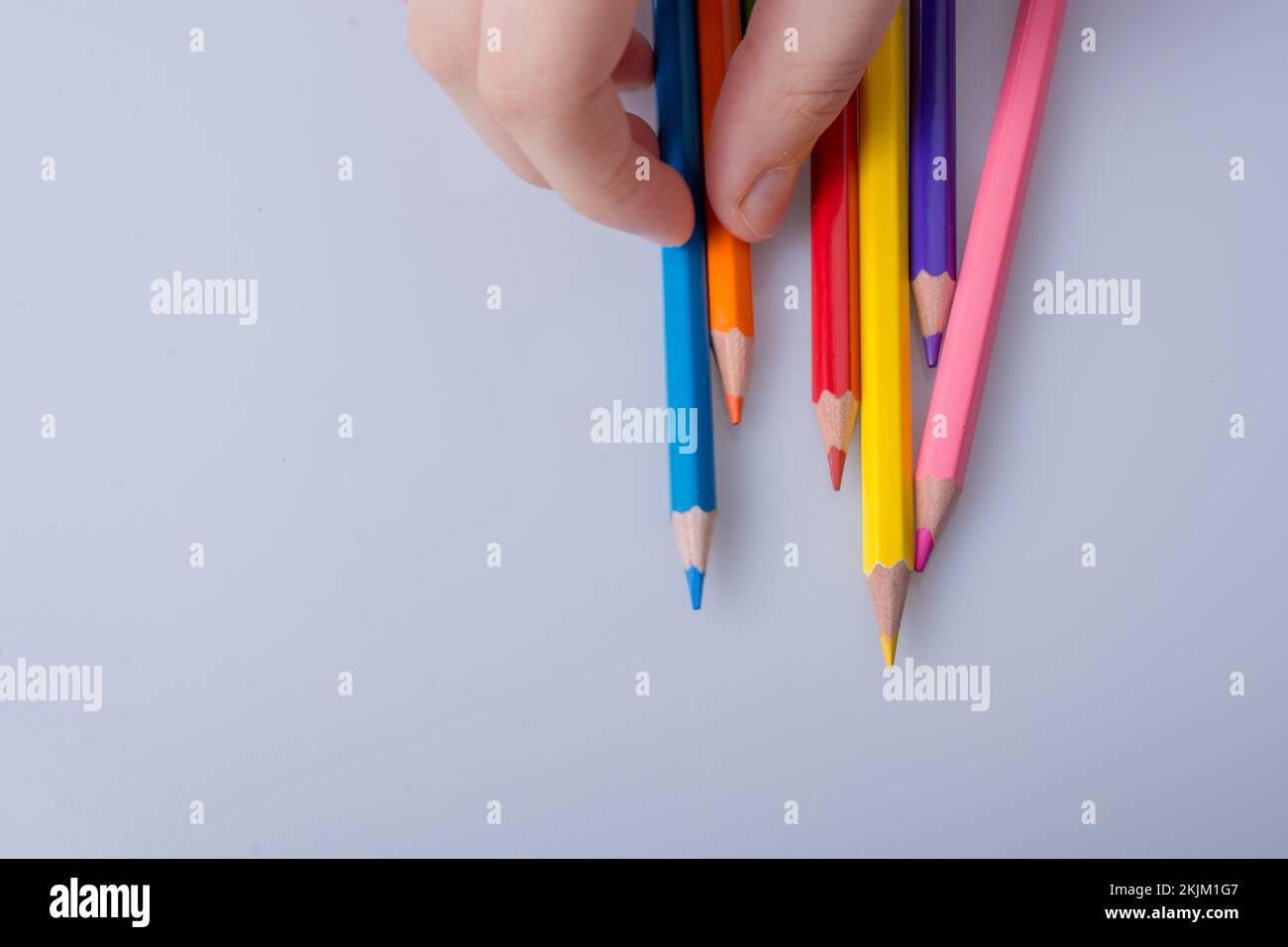 Hand holding color Pencils placed on a white background Stock Photo - Alamy