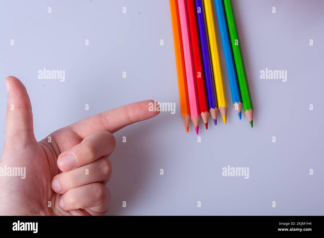 Hand holding color Pencils placed on a white background Stock Photo - Alamy