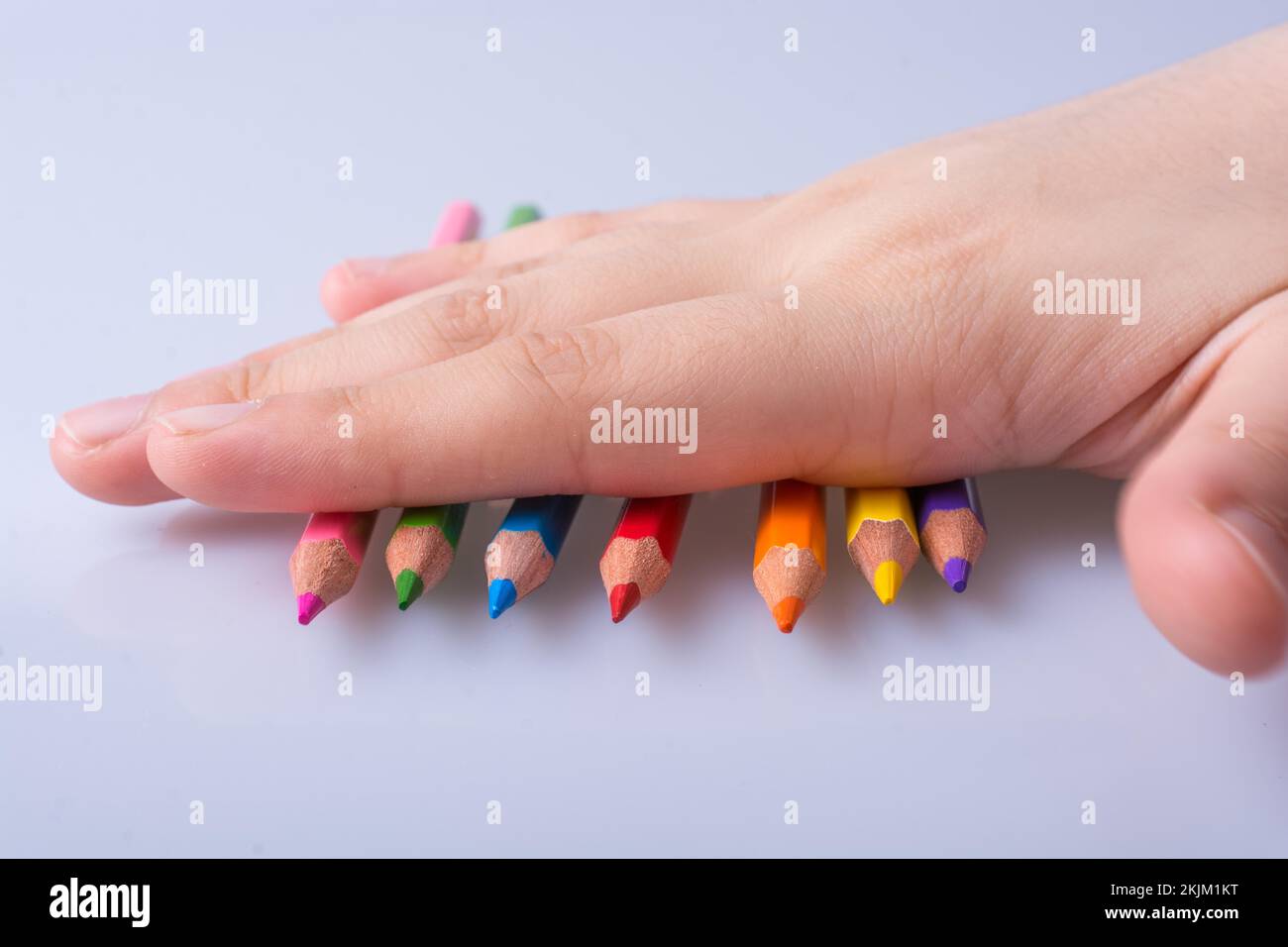 Hand holding color Pencils placed on a white background Stock Photo - Alamy