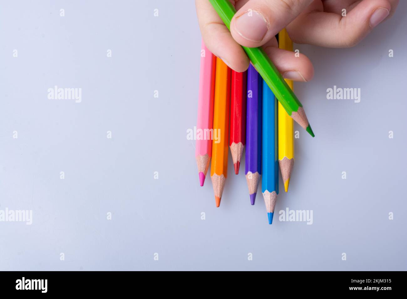 Hand holding color Pencils placed on a white background Stock Photo - Alamy