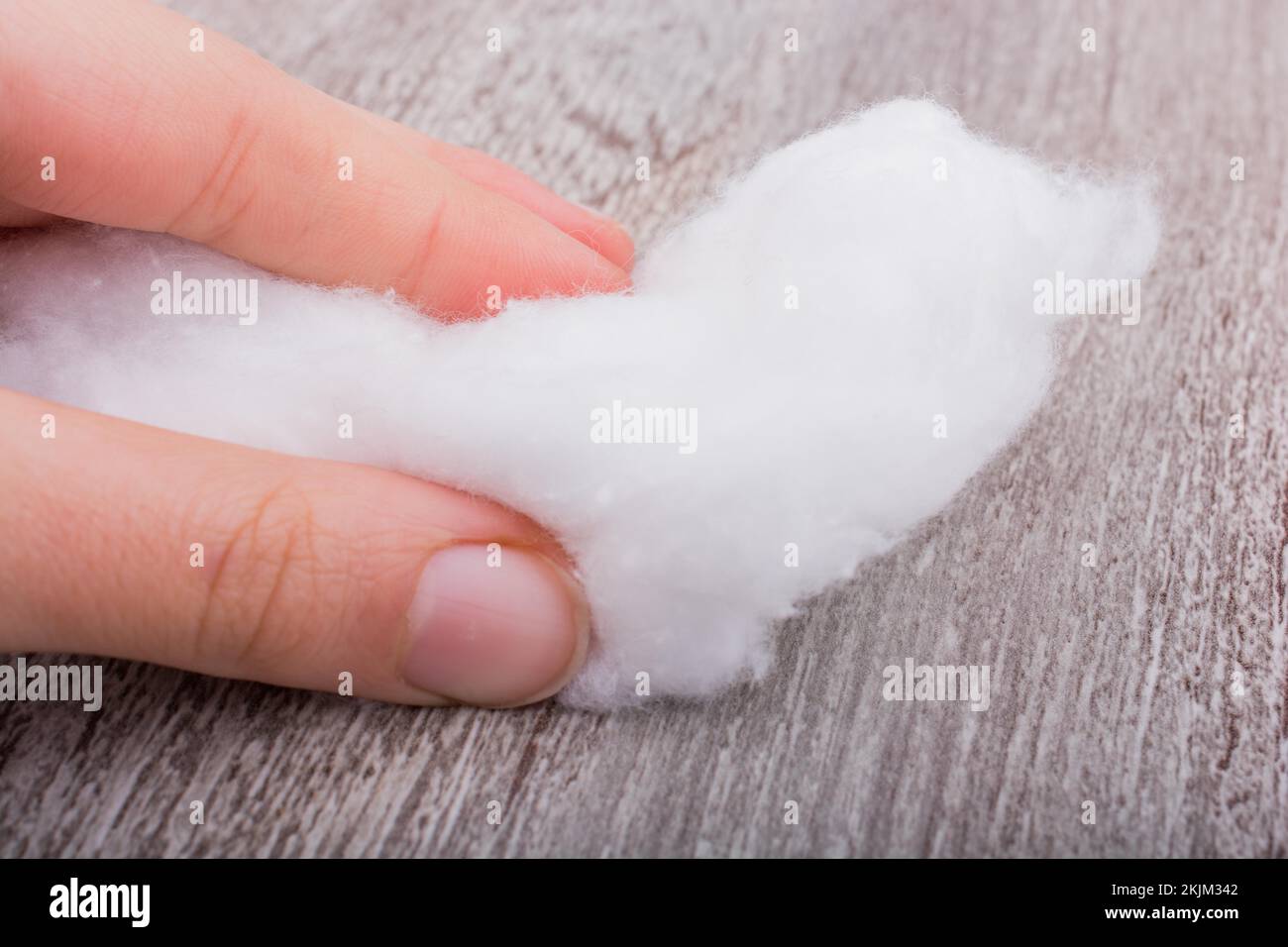 Hand holding some cotton in hand on a grey background Stock Photo - Alamy
