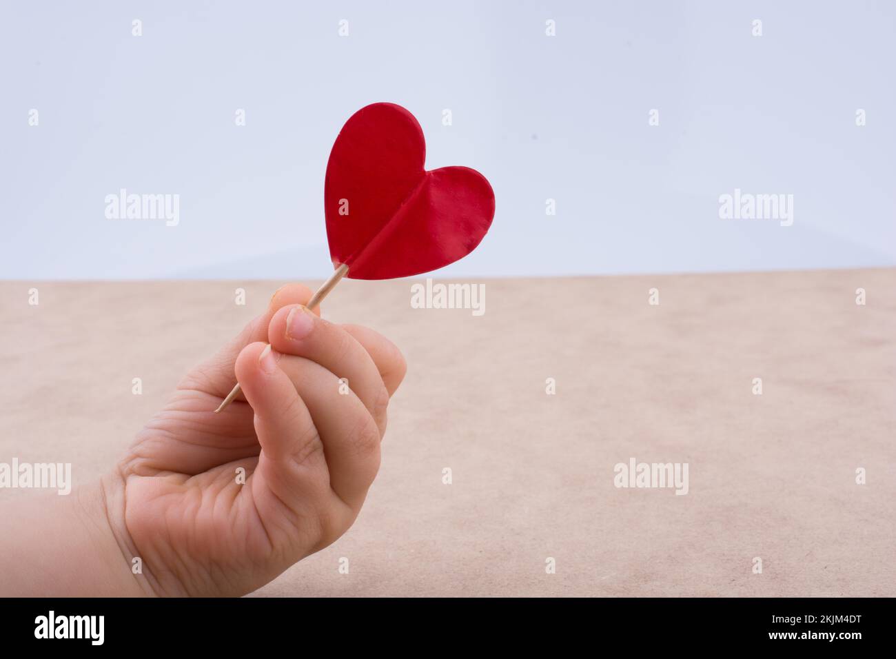 Little red color heart shape at the top of a stick in hand Stock Photo ...