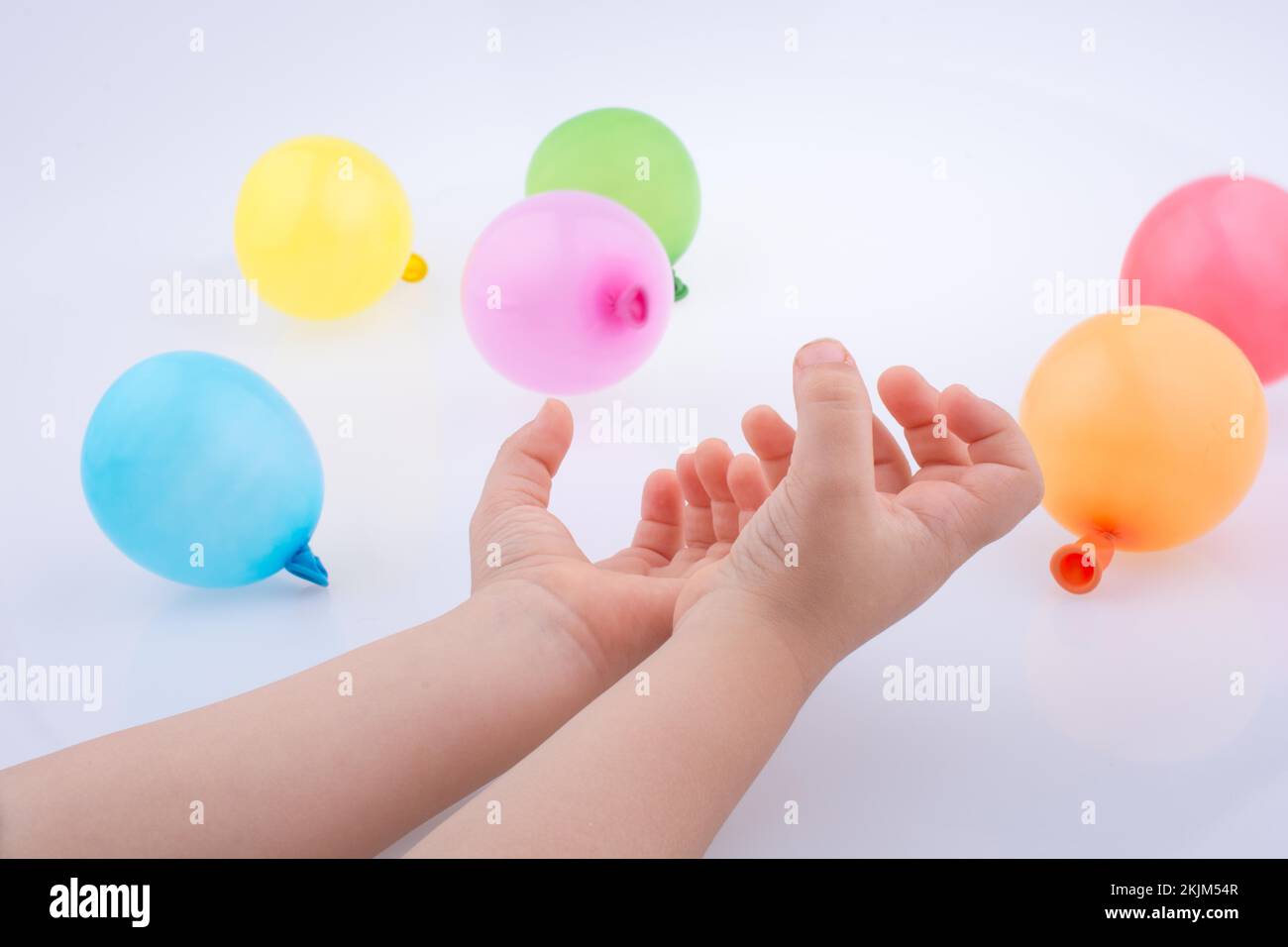 Hand holding colorful balloons on a white background Stock Photo - Alamy