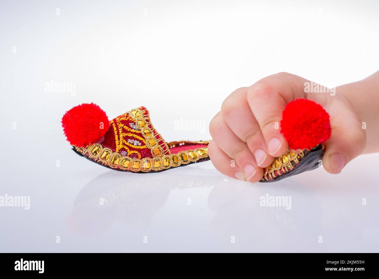 Traditional slippers in hand on white background Stock Photo - Alamy
