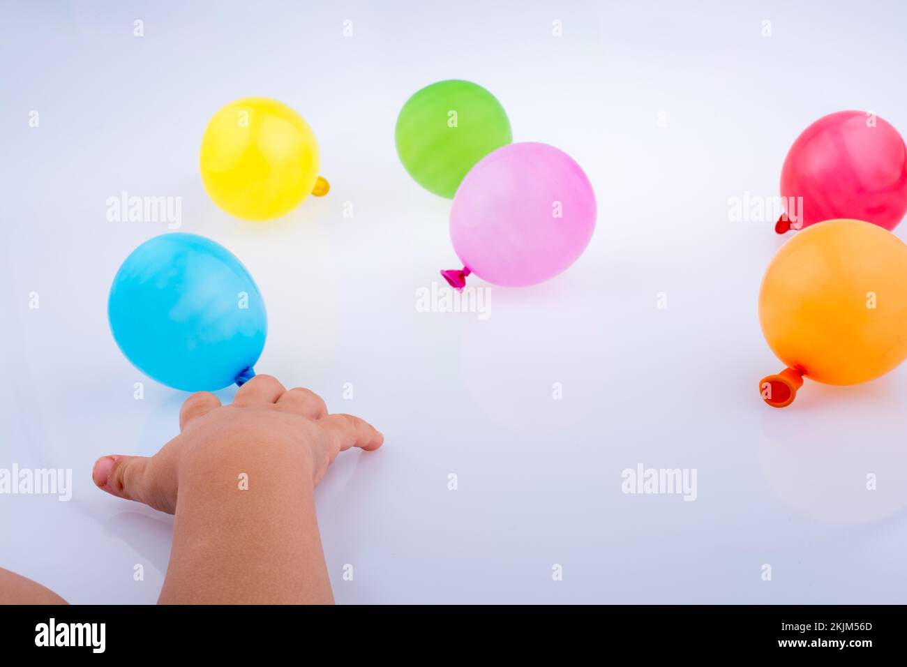 Hand holding colorful balloons on a white background Stock Photo - Alamy