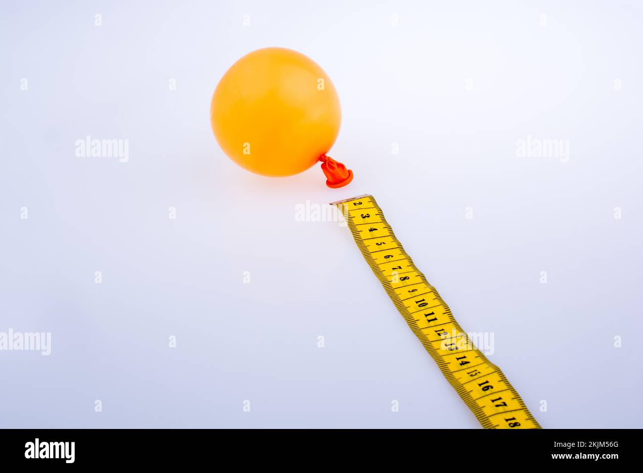 Yellow color measuring tape and a balloon on a white background Stock ...