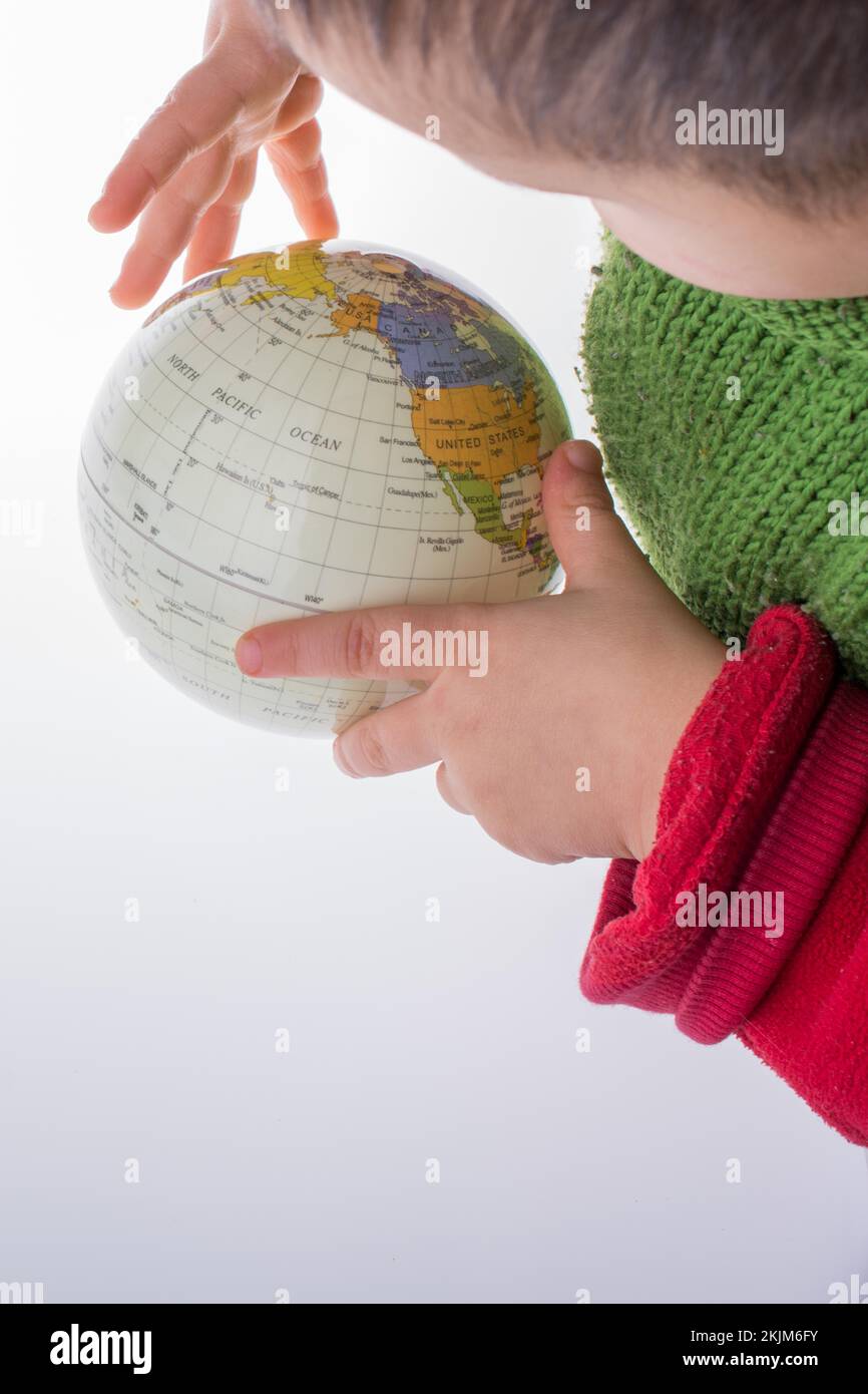 Child holding a globe in on a white background Stock Photo - Alamy