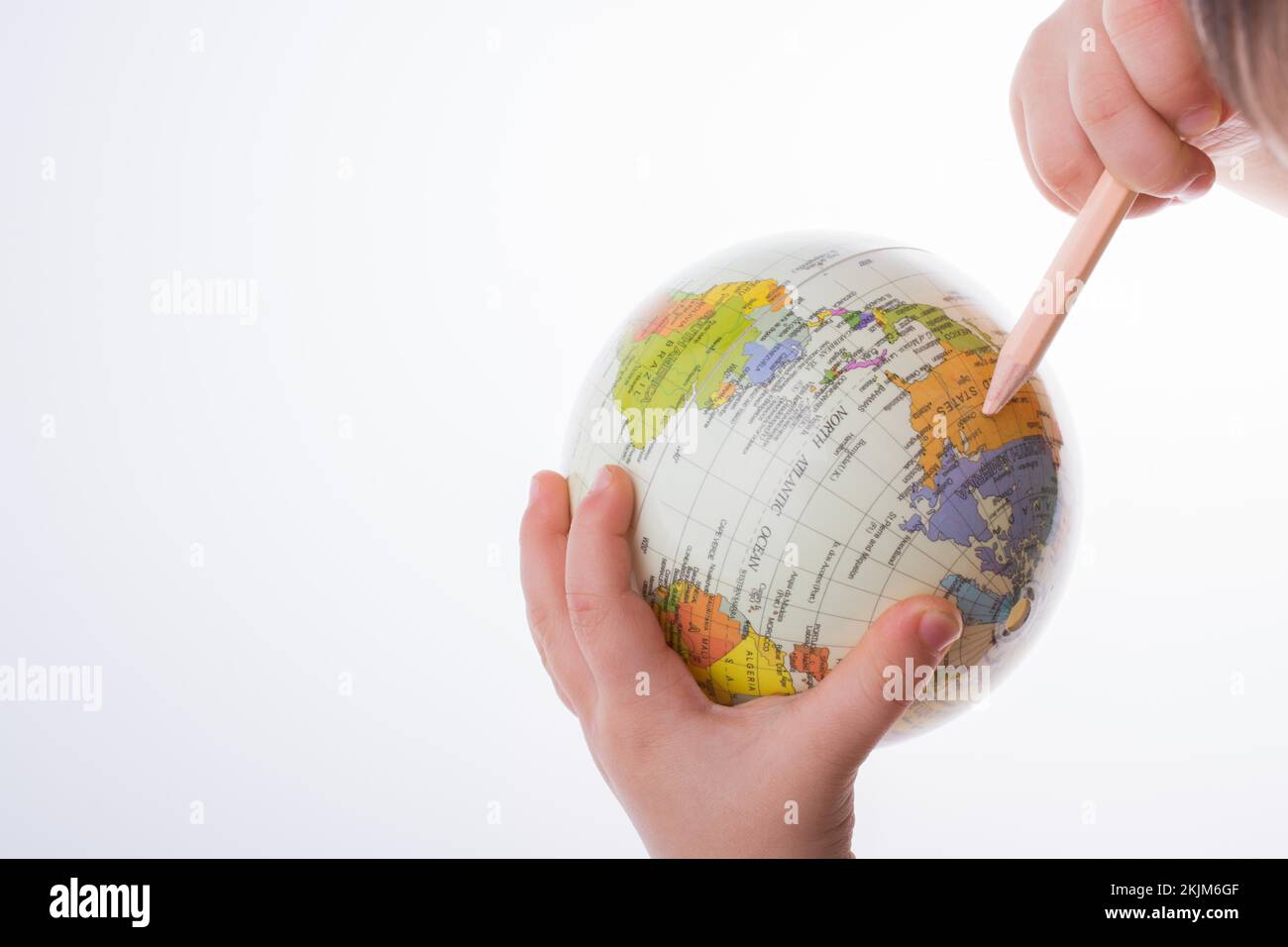 Child holding a globe and a pen in on a white background Stock Photo ...