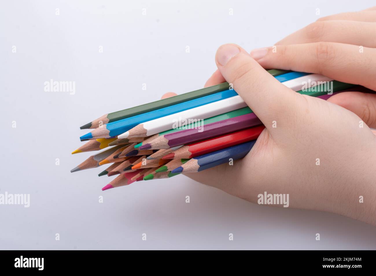 Hand holding color Pencils placed on a white background Stock Photo - Alamy