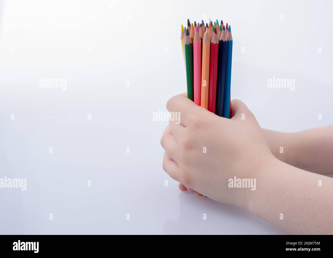 Hand holding color Pencils placed on a white background Stock Photo - Alamy