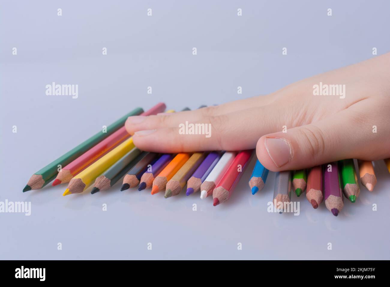 Hand holding color Pencils placed on a white background Stock Photo - Alamy