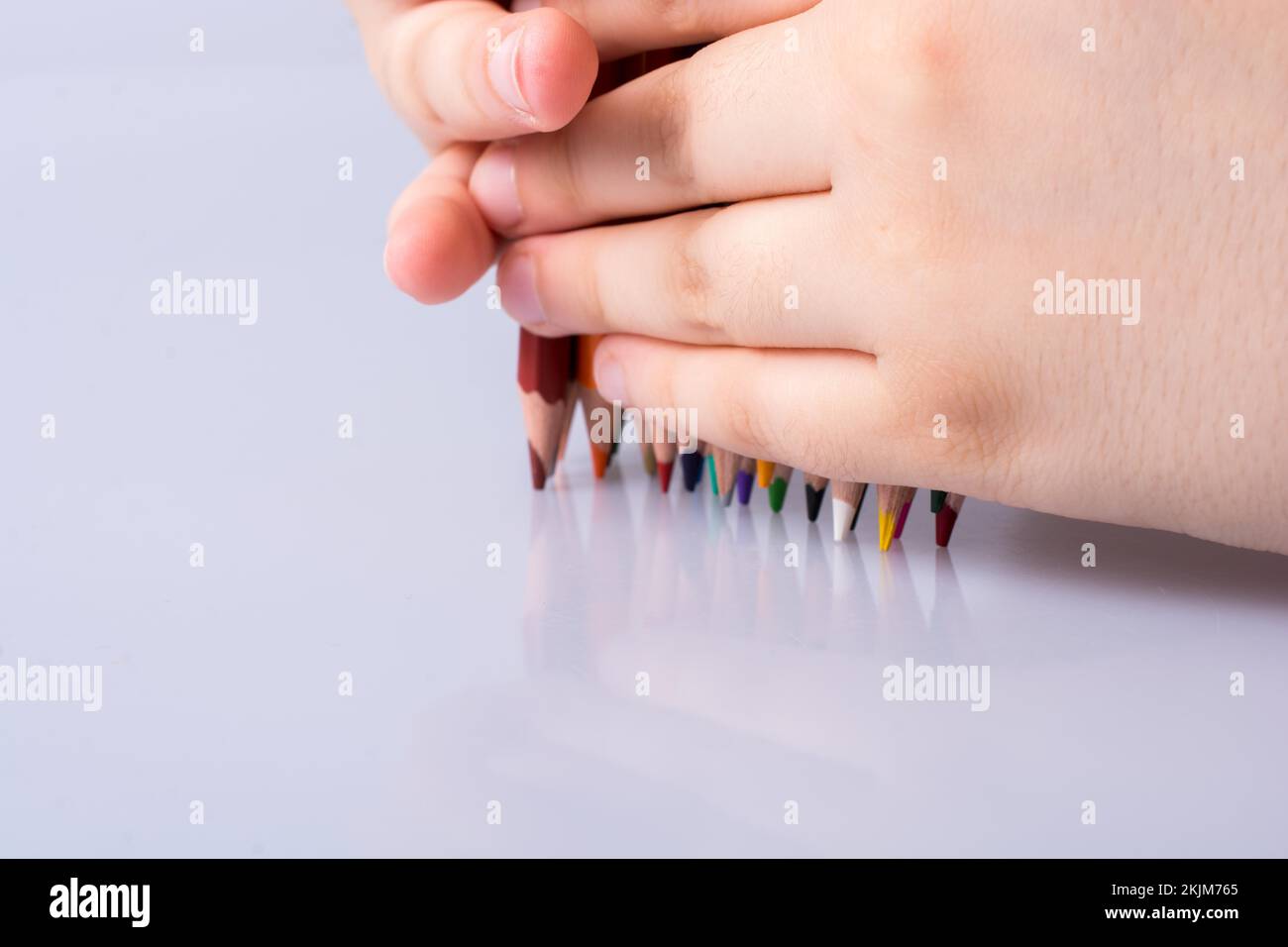 Hand holding color Pencils placed on a white background Stock Photo - Alamy