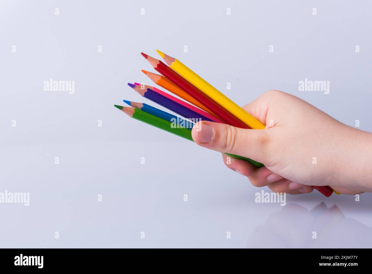 Hand holding color Pencils placed on a white background Stock Photo - Alamy
