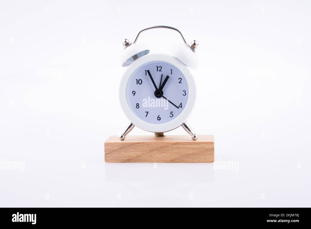 Alarm clock and building block on white background Stock Photo - Alamy