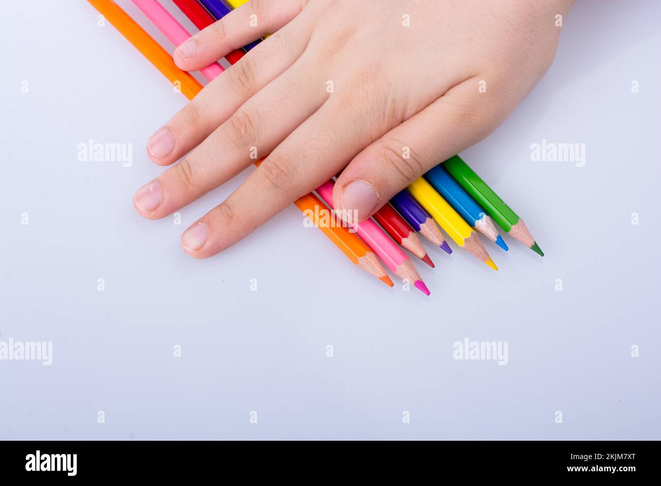 Hand holding color Pencils placed on a white background Stock Photo - Alamy