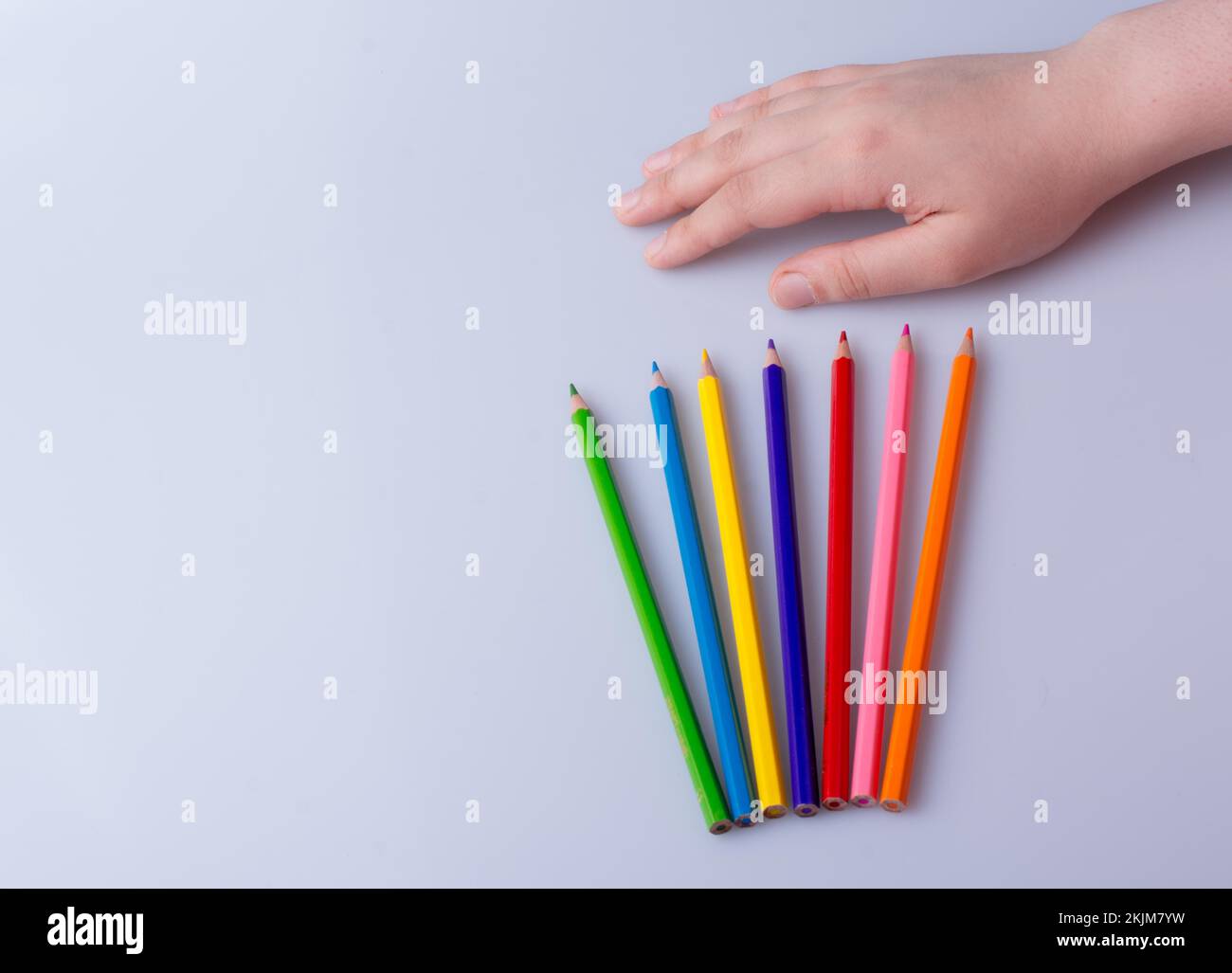 Hand holding color Pencils placed on a white background Stock Photo - Alamy