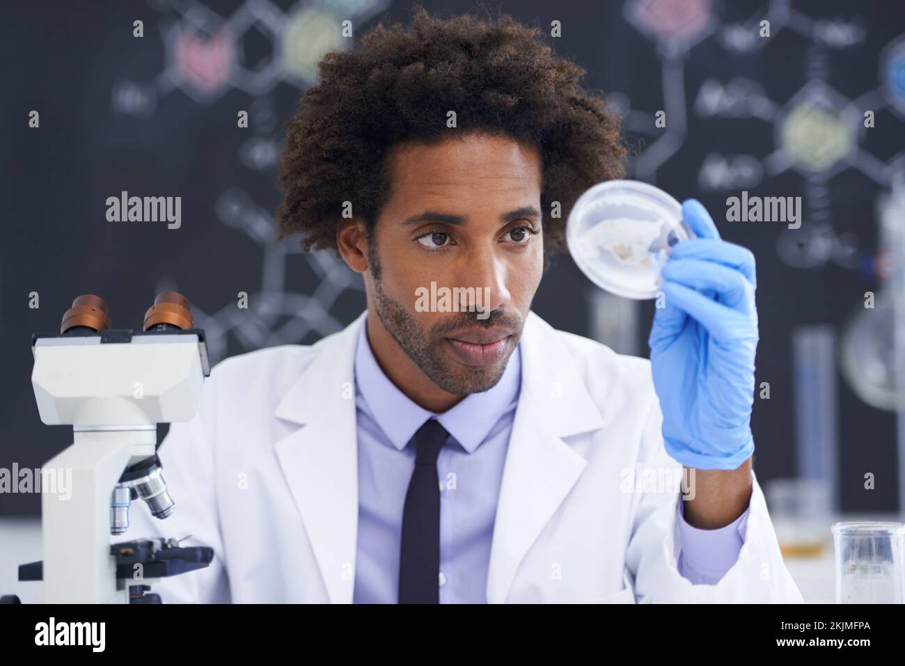 Lets see what we have here. a male scientist looking at the contents of ...