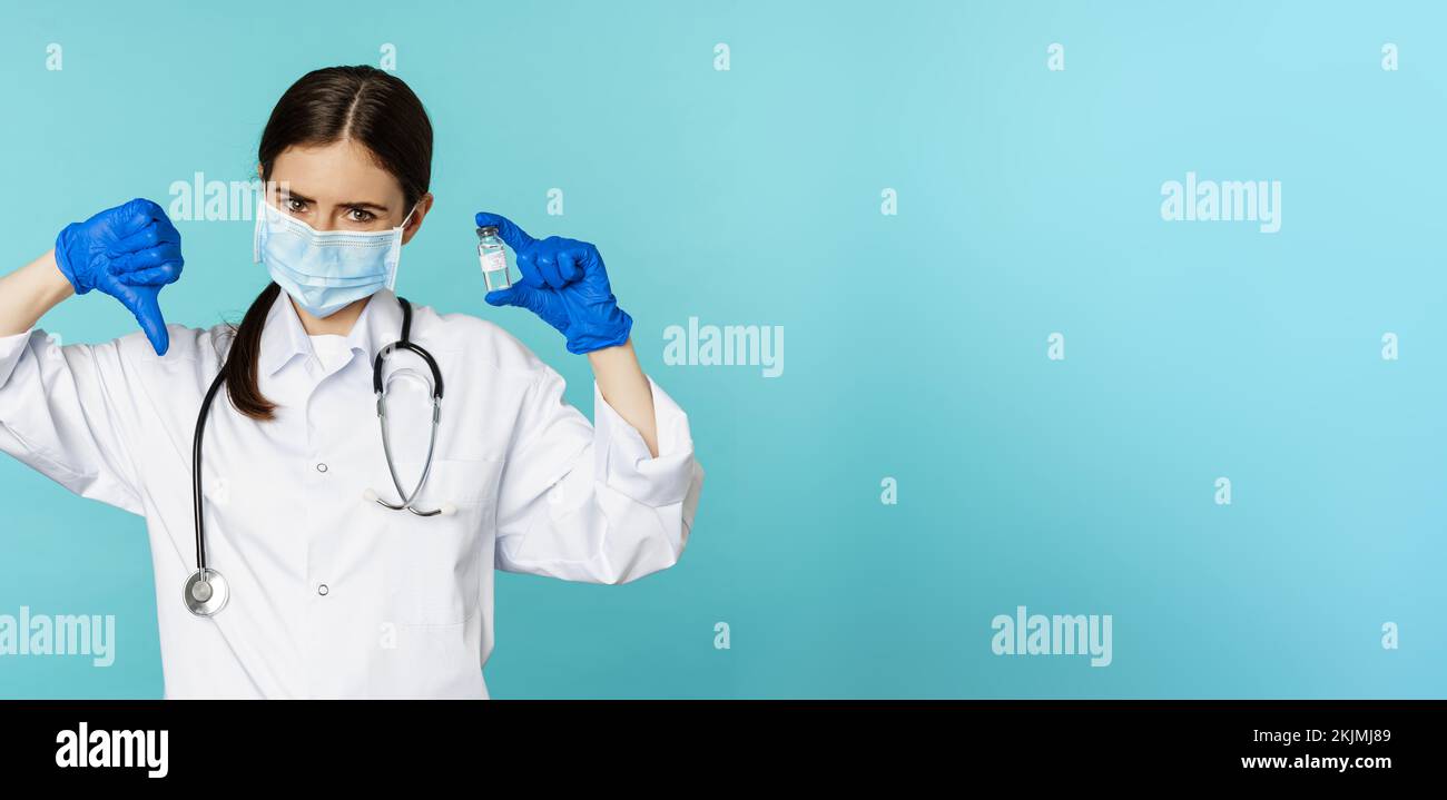 Sad and disappointed young doctor, woman showing vaccine and dislike ...