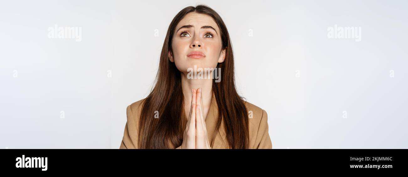 Hopeful corporate woman, student praying, begging god, looking up and ...