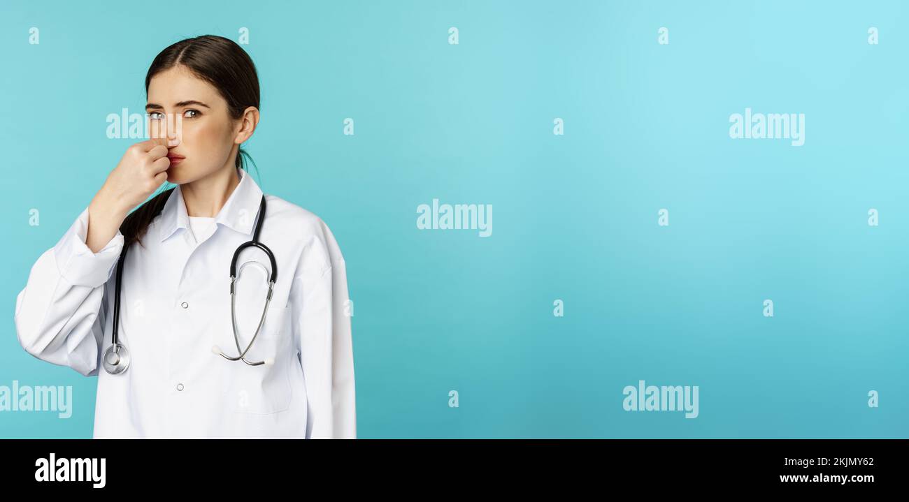 Woman doctor dislike, shut nose from bad smell, reek, standing against ...