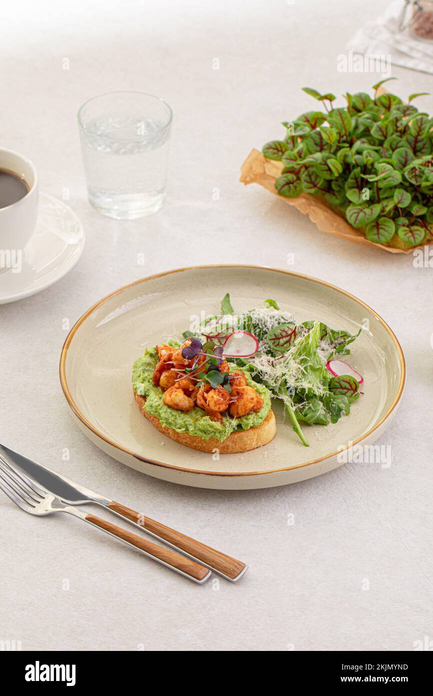 Portion of avocado toast with shrimp and salad Stock Photo - Alamy