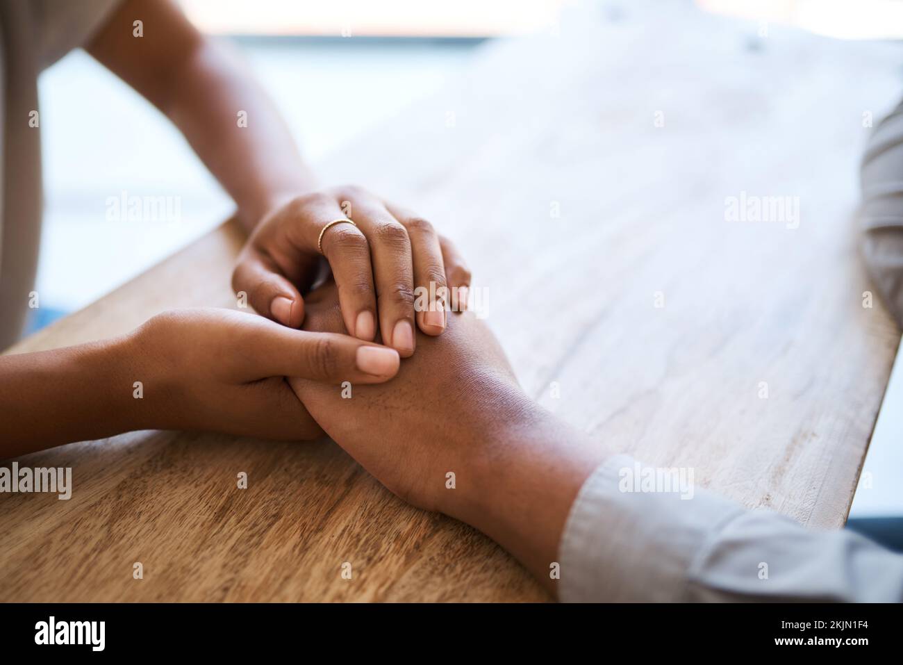 Couple, holding hands and support on table in closeup for help, care ...