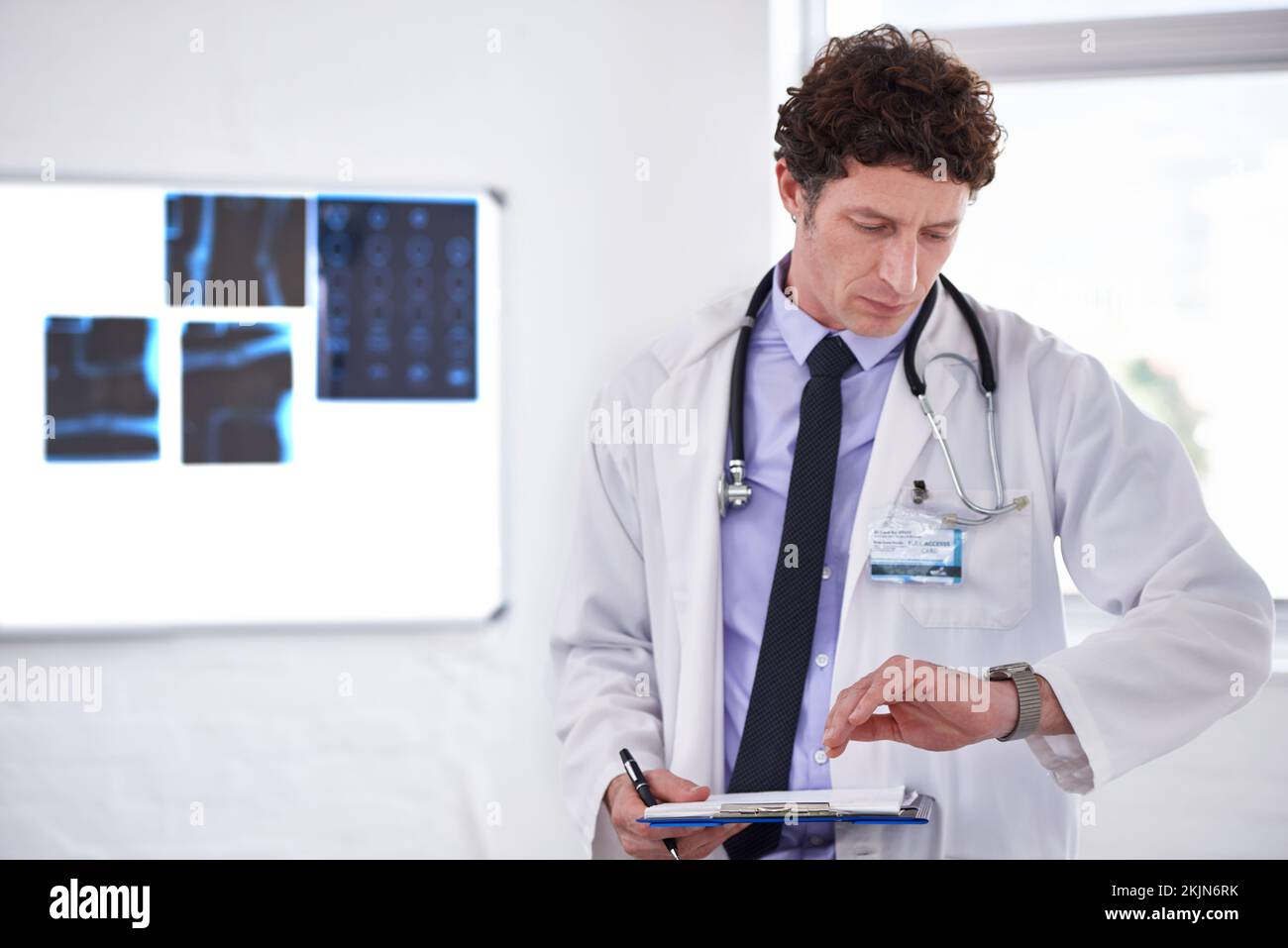 Its save a life o clock. a male doctor checking the time Stock Photo ...