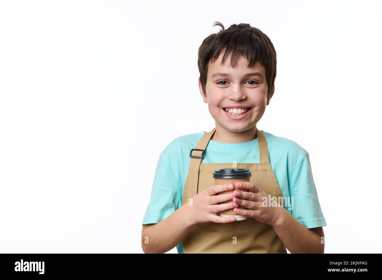 Handsome smiling preteen boy wearing blue t-shirt and beige chef's ...