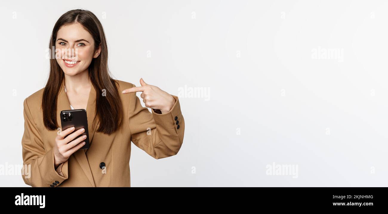 Enthusiastic saleswoman, business woman pointing finger at mobile phone ...