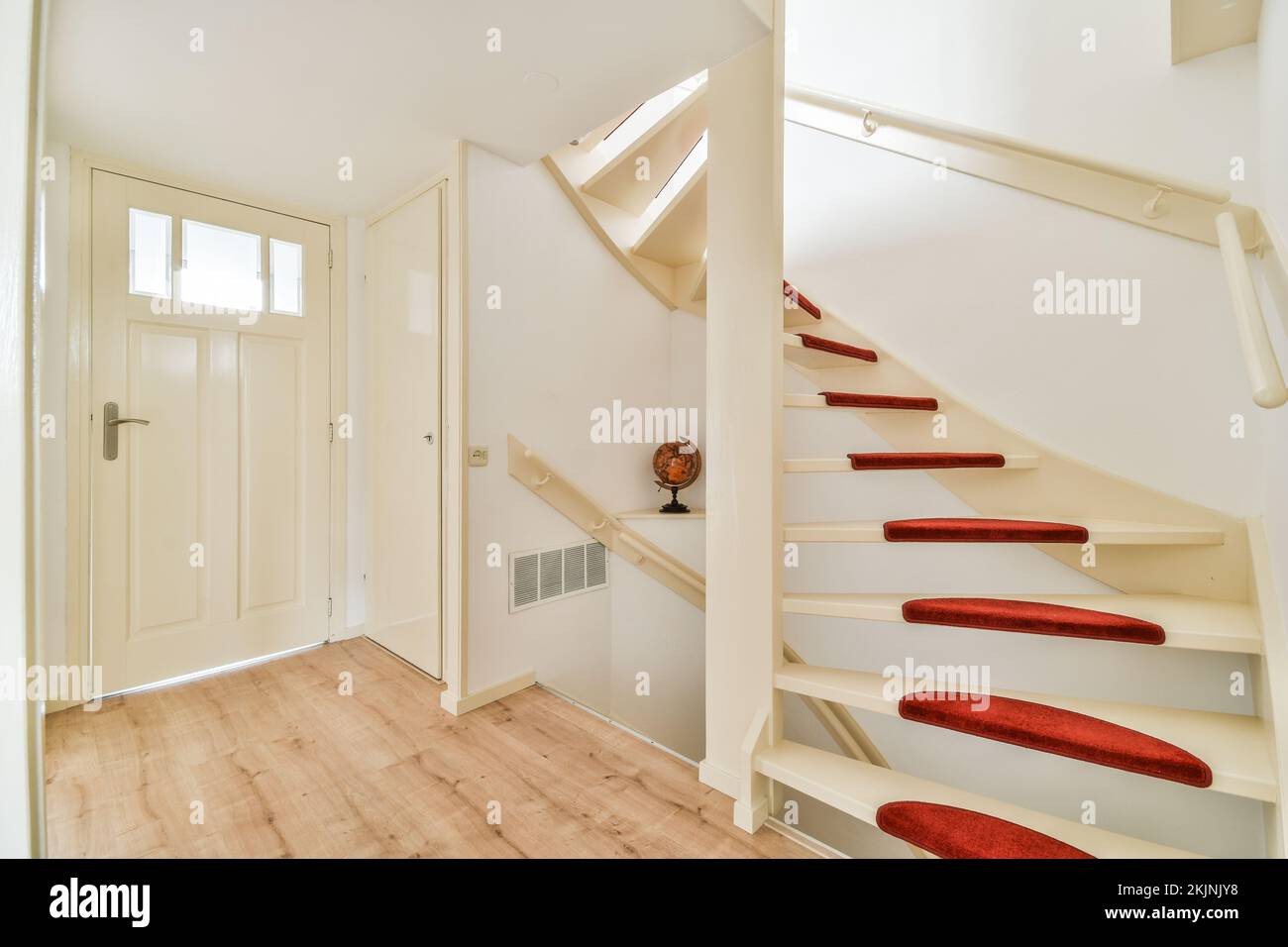 White hallway with wooden stairway leading to second floor Stock Photo ...