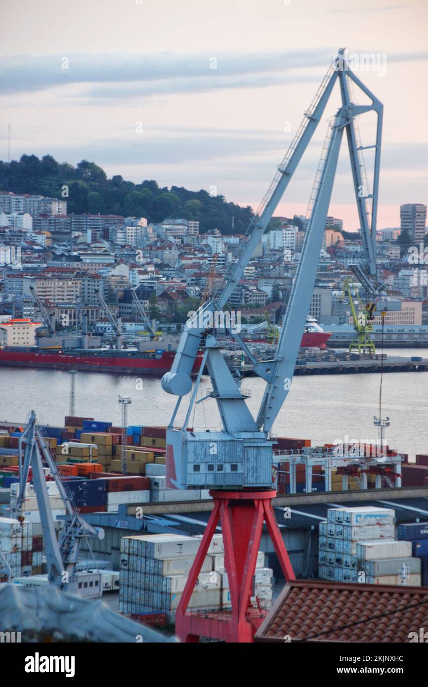 A vertical crane for loading and unloading with buildings and trees in ...