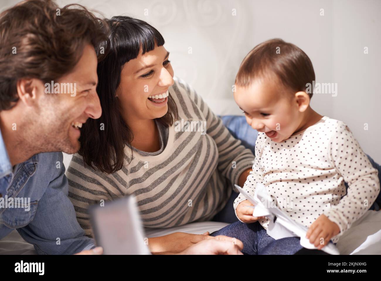 Toys and technology. a happy mother and father showing their baby ...