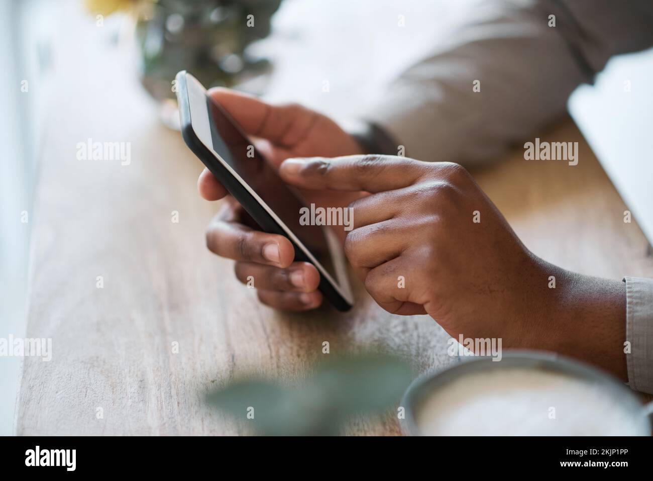 Hand, table and phone with a man browsing the internet online ot ...